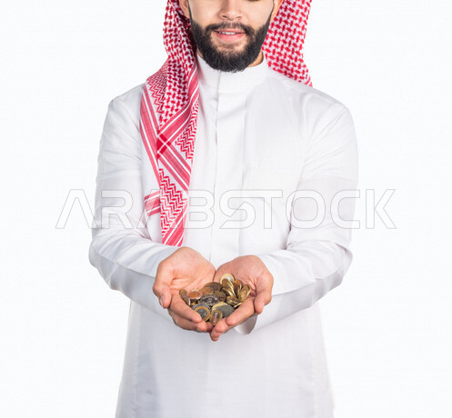 Portrait of a Gulf Arab man holding in his hand a pile of coins ...