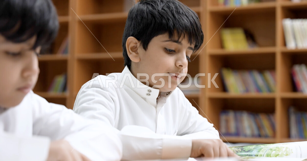 Two Saudi Arabian Gulf students in the school library, enjoying reading ...