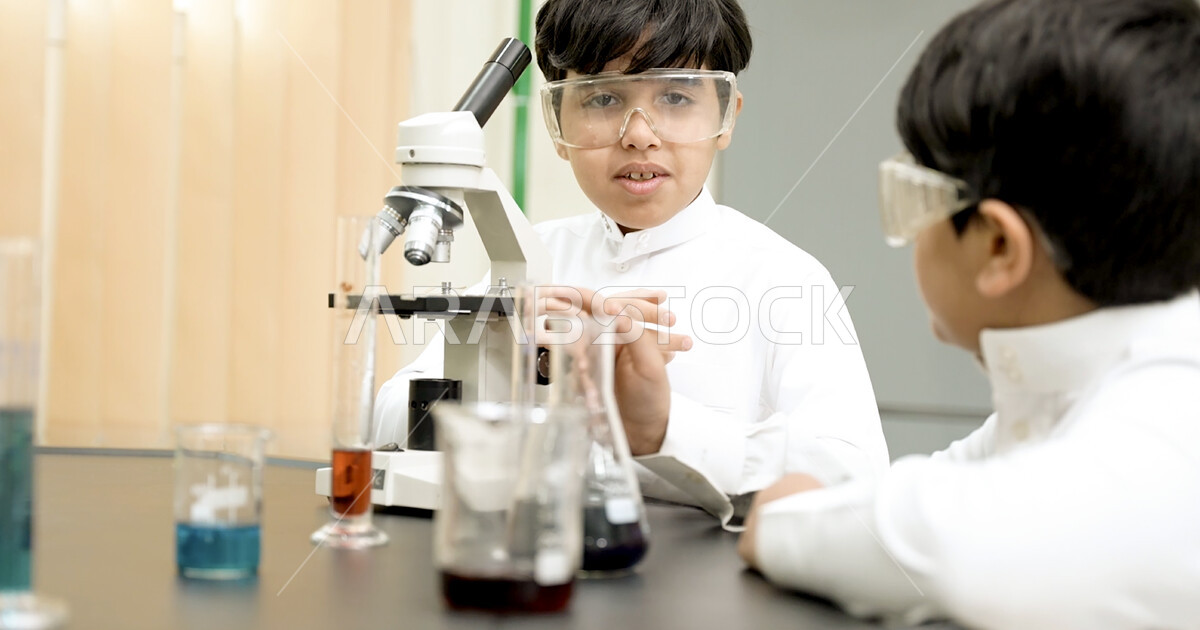 Two Saudi Arabian Gulf students wearing school uniforms, conducting ...