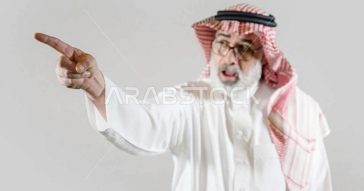Portrait of an old Saudi Arabian Gulf Arab man pointing with his index ...