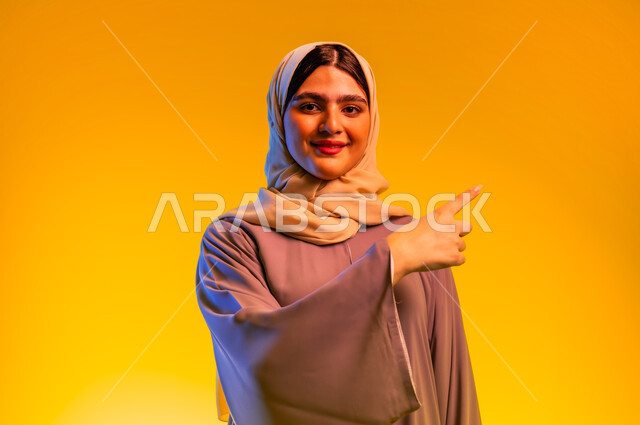 Hand gestures and signs indicating this place (here), a Saudi woman ...