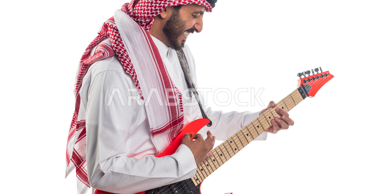 Portrait of a Saudi Arabian Gulf man playing the electric guitar ...