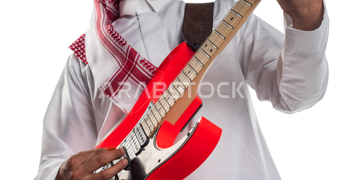 A close-up of a Saudi Arabian Gulf man playing the electronic guitar ...