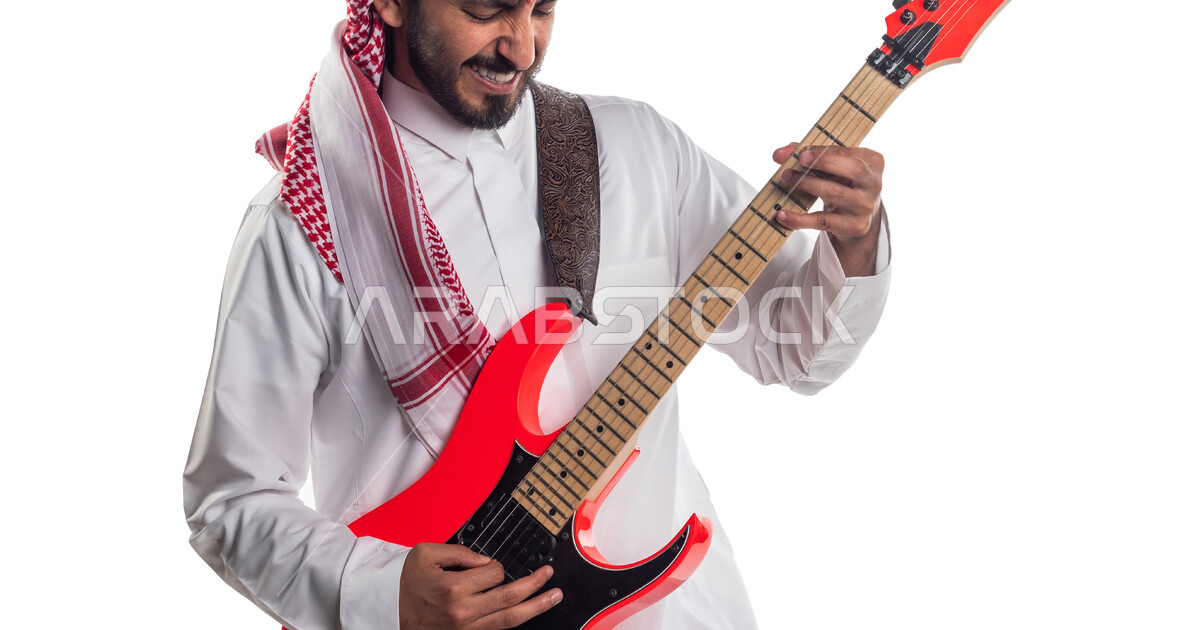 Portrait of a Saudi Arabian Gulf man playing the electric guitar ...