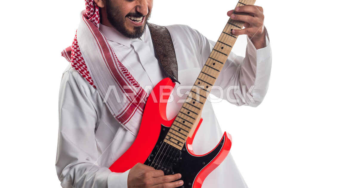 Portrait of a Saudi Arabian Gulf man playing the electric guitar ...
