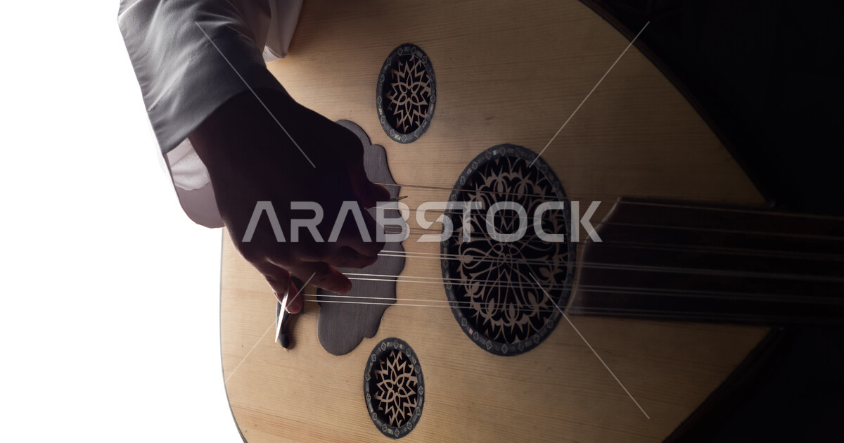 A silhouette of a Saudi Arabian Gulf man playing the Oud instrument ...