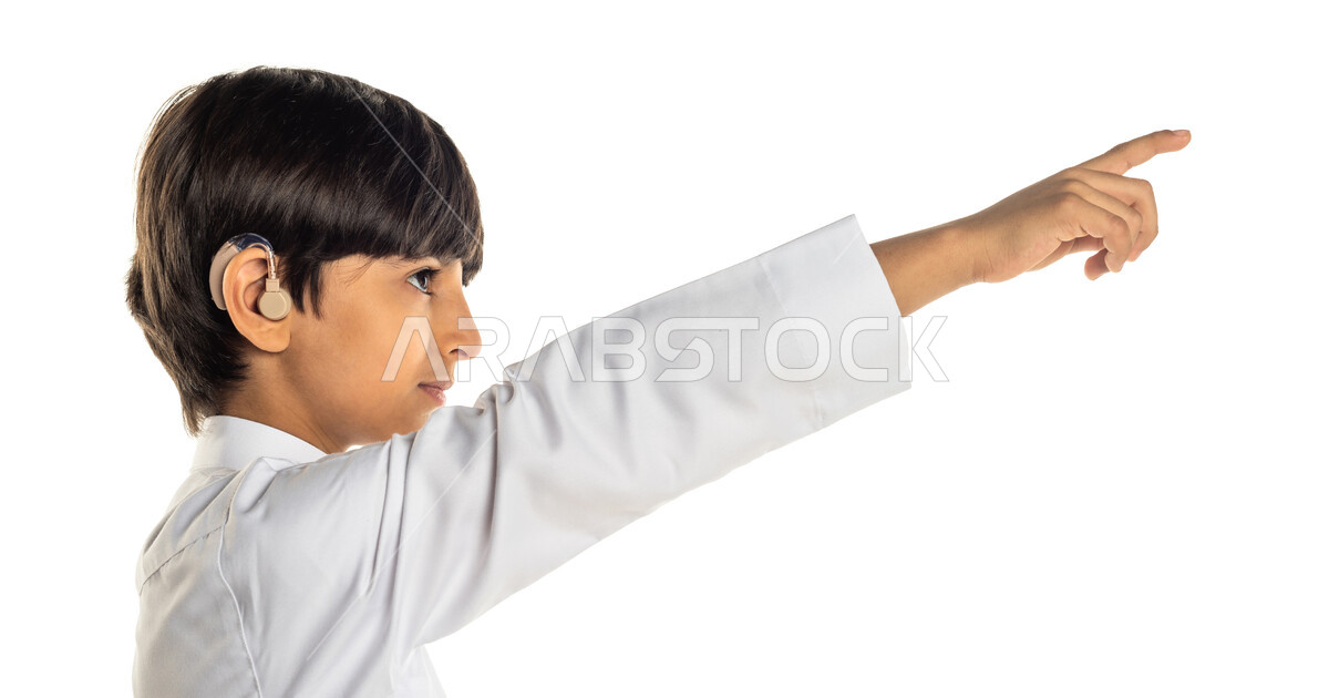 Portrait of a deaf Saudi Arabian Gulf child, wearing a hearing aid and ...