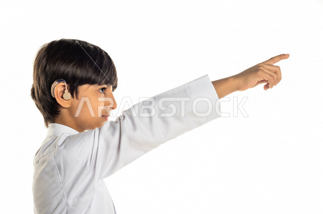 Portrait of a deaf Saudi Arabian Gulf child, wearing a hearing aid and ...