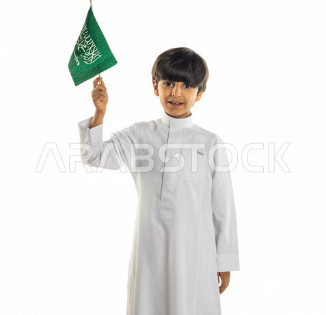 Portrait of a Saudi Arabian Gulf boy holding the flag of Saudi Arabia ...