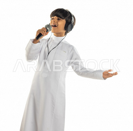Portrait of a Saudi Arabian Gulf child wearing a headphone, holding a ...