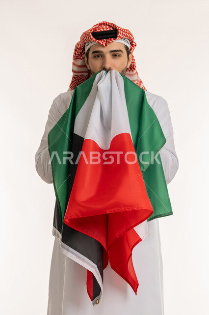 Kissing the Kuwaiti flag with pride and honor, showing feelings of love ...