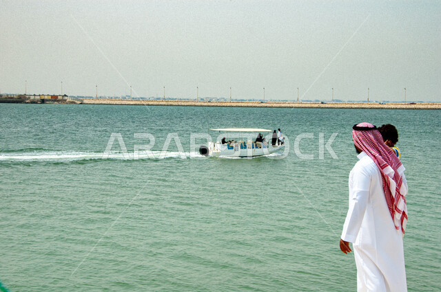 Having fun on the beach, a back view of a Saudi Arabian Gulf man ...