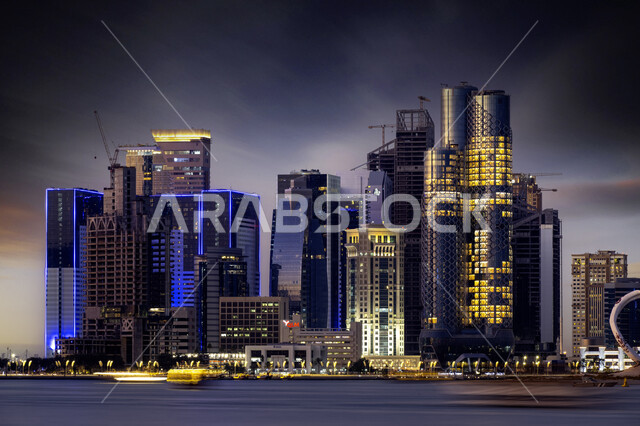 Towers and skyscrapers lit at night in the city of Doha on the shores ...
