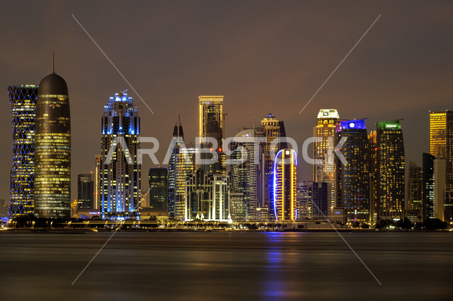 Towers and skyscrapers lit at night in the city of Doha on the shores ...