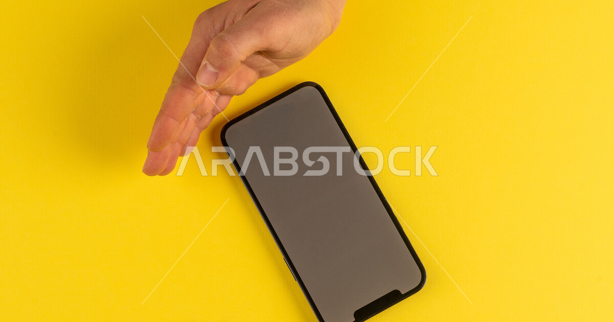 Close-up of the hand of a Saudi Arabian Gulf man using a mobile phone ...