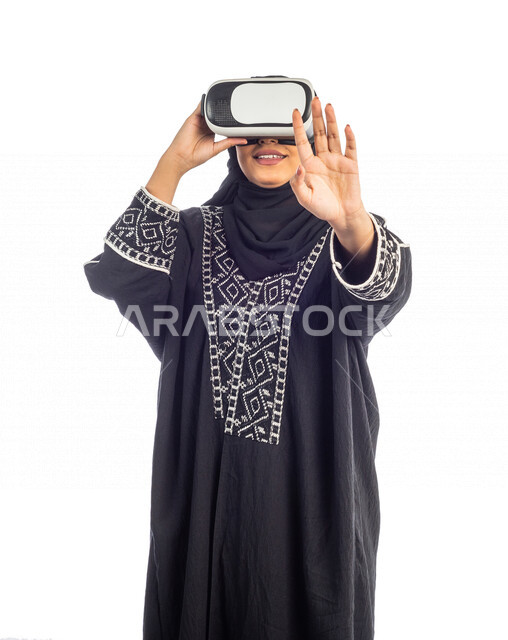 Portrait of a Saudi Arabian Gulf woman wearing a VR , pointing with her ...