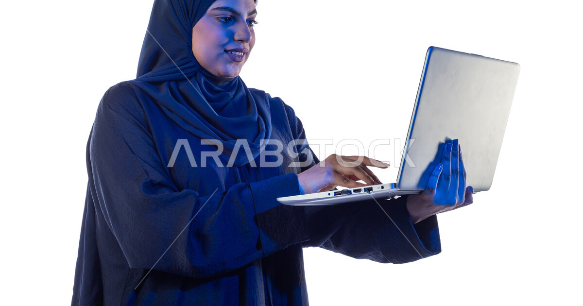Portrait of a Saudi Arabian Gulf woman carrying a laptop, remote work ...