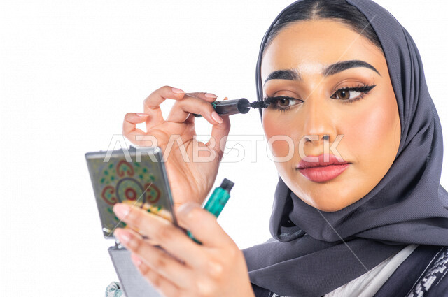 Portrait of a Saudi Arabian Gulf woman holding a cosmetic tool (mascara ...