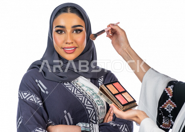 Portrait of a Saudi Arabian Gulf woman holding a cosmetic tool (brush ...