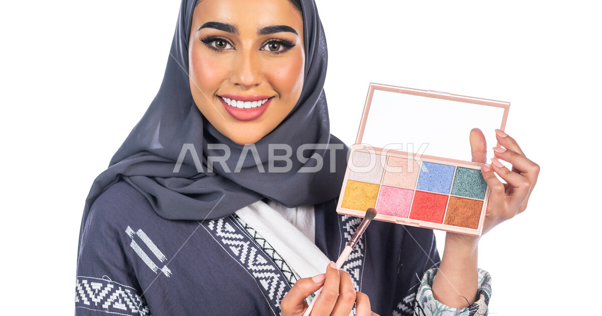 Portrait of a Saudi Arabian Gulf woman holding one of the cosmetics ...
