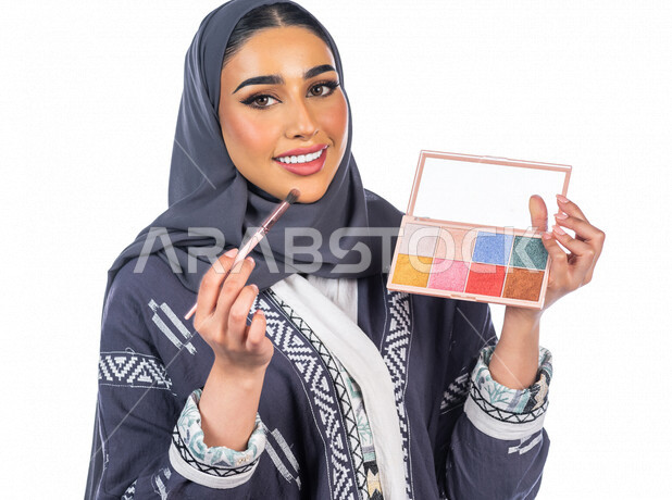 Portrait of a Saudi Arabian Gulf woman holding one of the cosmetics ...