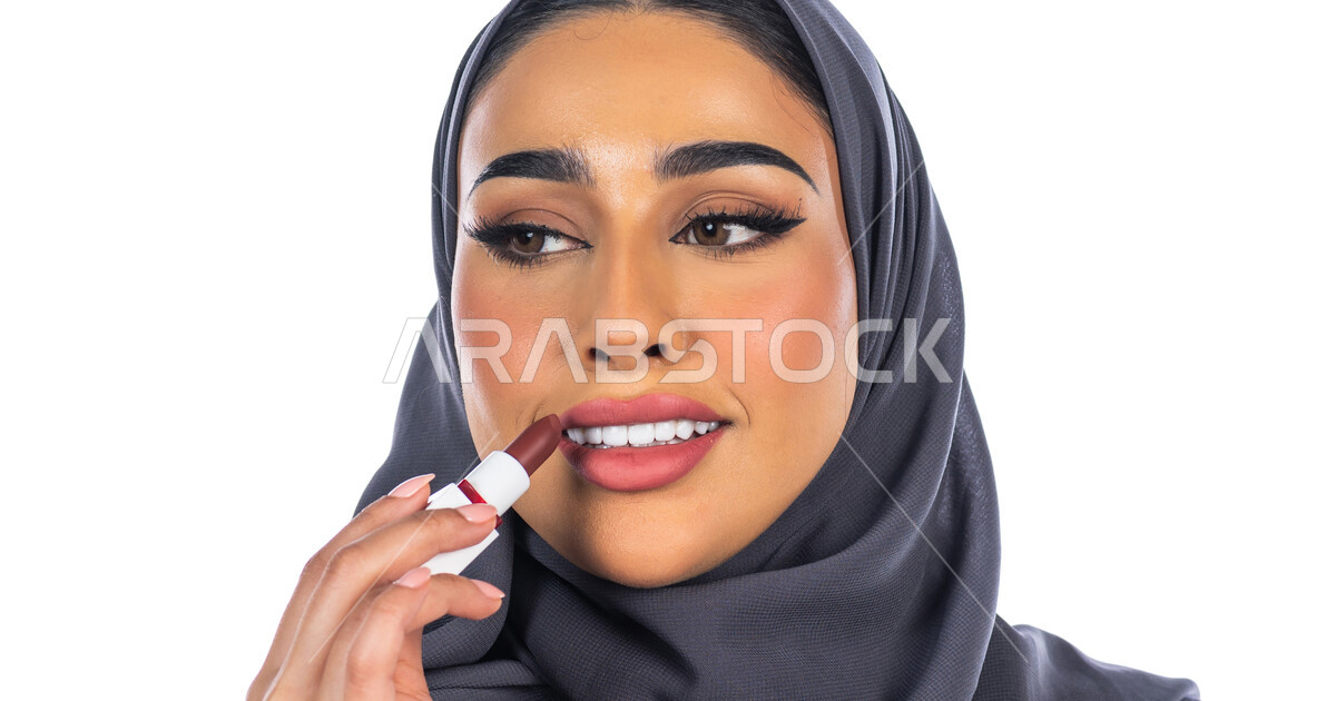 Portrait of a Saudi Arabian Gulf woman holding a cosmetics (lipstick ...