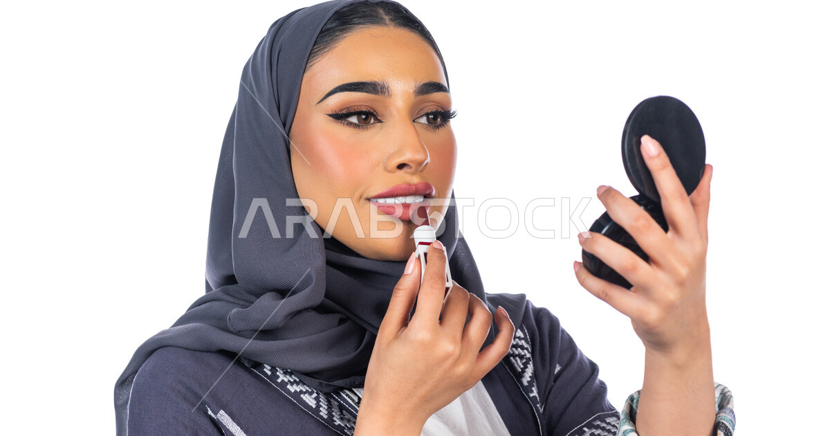 Portrait of a Saudi Arabian Gulf woman holding a cosmetics (lipstick ...