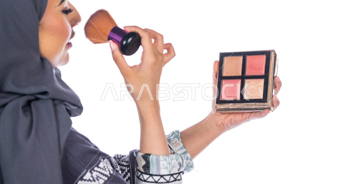 Portrait of a Saudi Arabian Gulf woman holding a cosmetic tool (brush ...