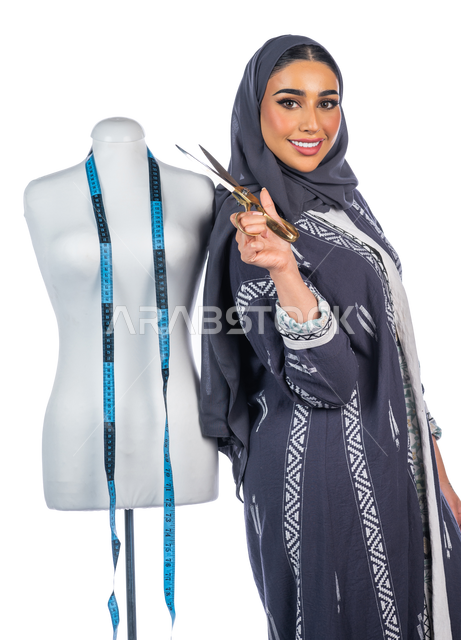 Portrait of a Saudi Arabian Gulf fashion designer working in the sewing ...
