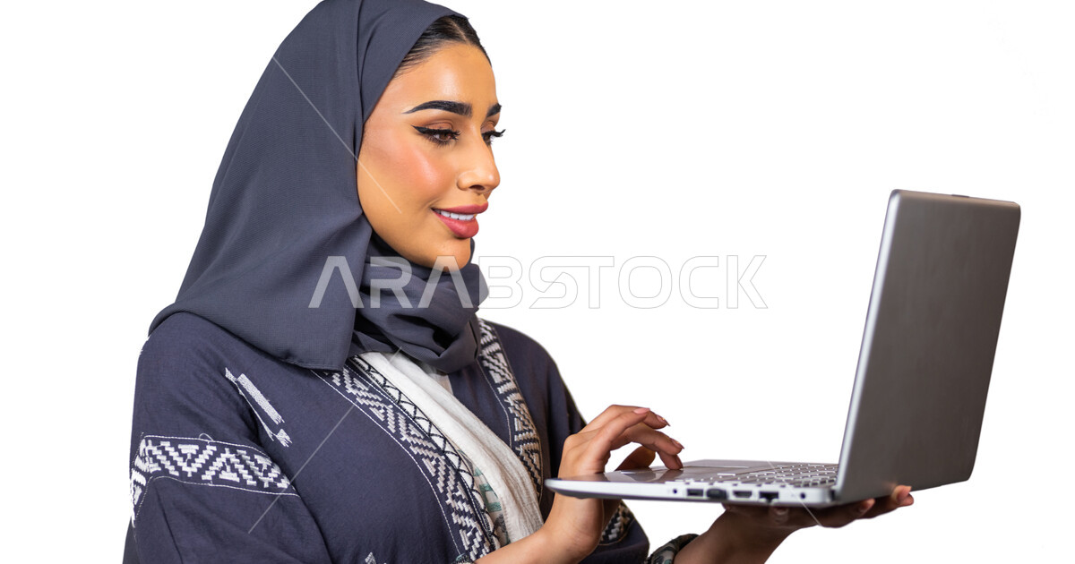 Portrait of a Saudi Arabian Gulf woman, using a laptop to accomplish ...