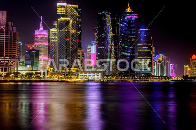 Reflection of illuminated buildings and structures at night on the sea ...