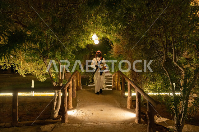 Walking in a park in Saudi Arabia, a Saudi Arabian Gulf man wearing a ...