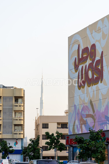 Mural of the word Wasl on a building in Al Karama area, Burj Khalifa in ...