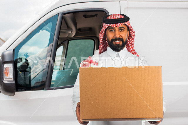 A Saudi Arabian Gulf man wearing a Saudi dress works in the delivery of ...
