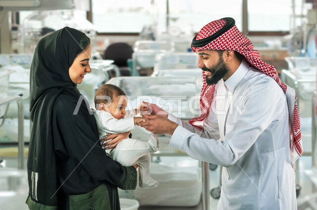 A Saudi Arabian Gulf couple carrying their newborn daughter, the family ...