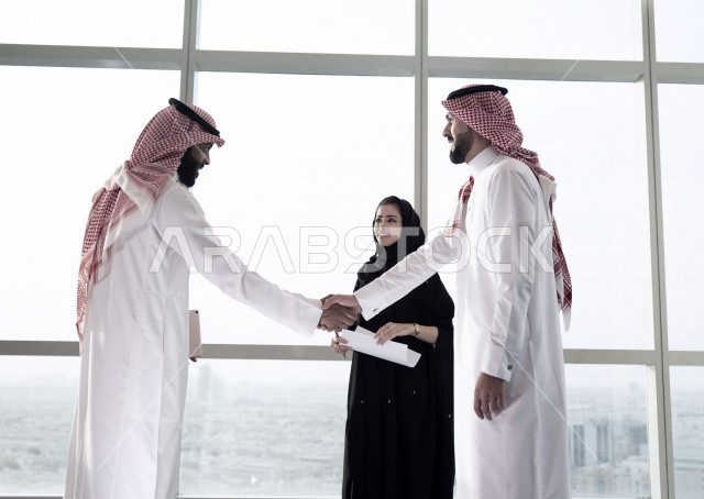 Two Saudi Arabian men shake hands after a successful business meeting ...