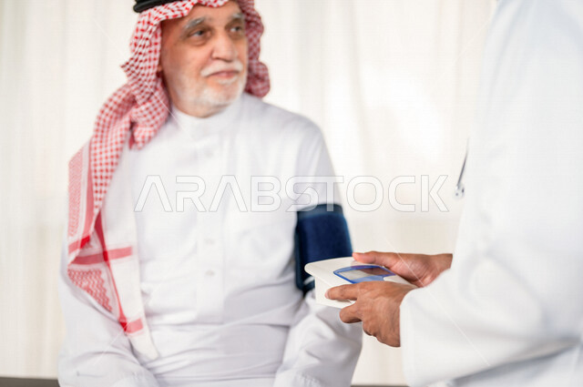 Portrait of a Saudi Arabian Gulf doctor checking the blood pressure of ...