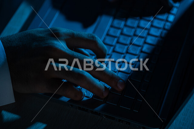 A close-up of the hand of a Saudi Arabian Gulf man using a laptop ...