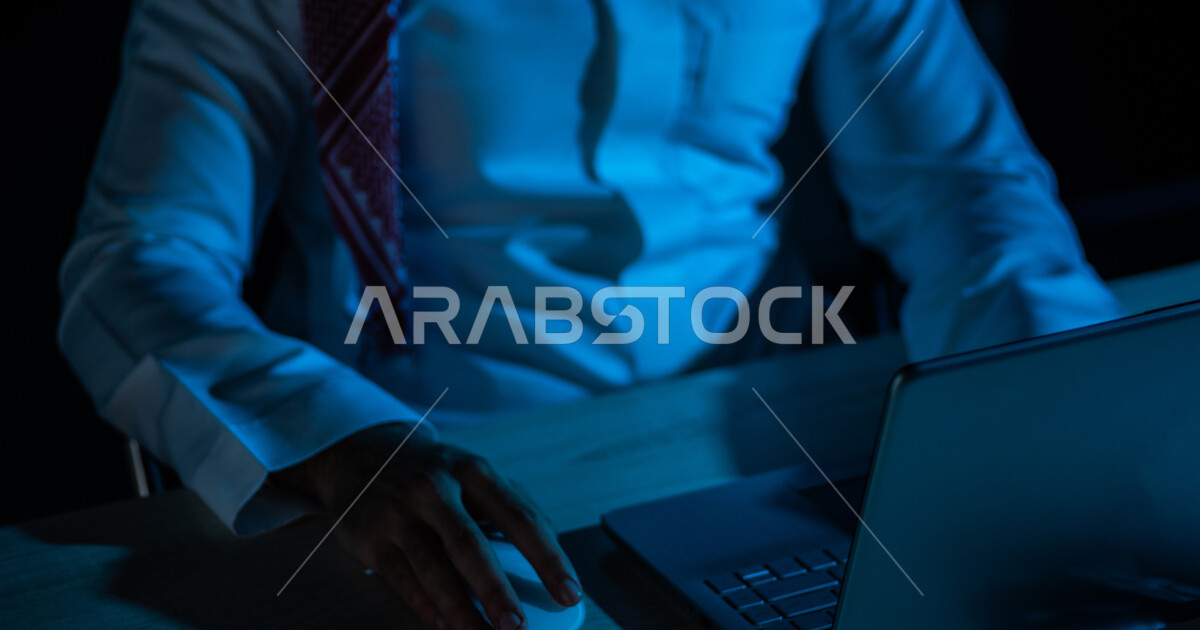 Close-up of the hand of a Saudi Arabian Gulf man using a laptop ...