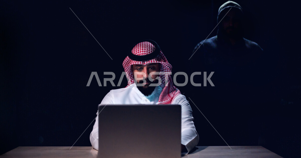 A Saudi Arabian Gulf man using his laptop, exposure to hacking and ...