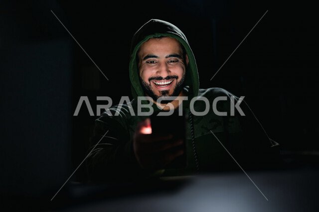 A young Saudi Arabian Gulf man with happy face gestures, working in the ...