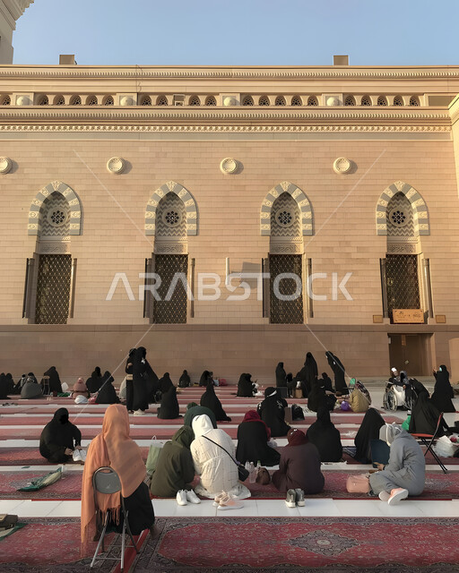 Muslims sitting in the outer complex of the Prophet's Mosque in Medina ...