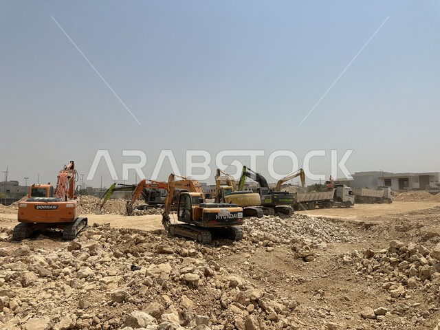 مفهوم الهندسة المعمارية والإنشاء، جرافات ضخمة تعمل في الحفر ورفع ...