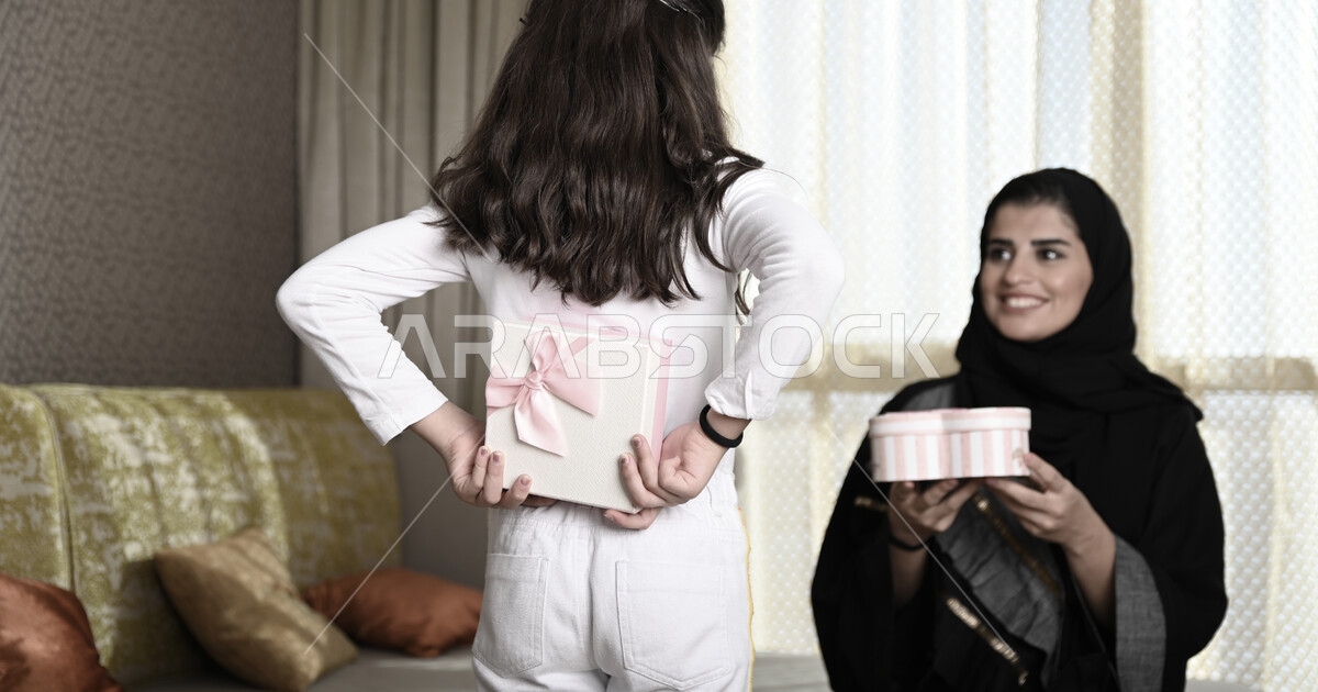A Saudi Arabian Gulf girl presents a gift to her mother on the occasion ...
