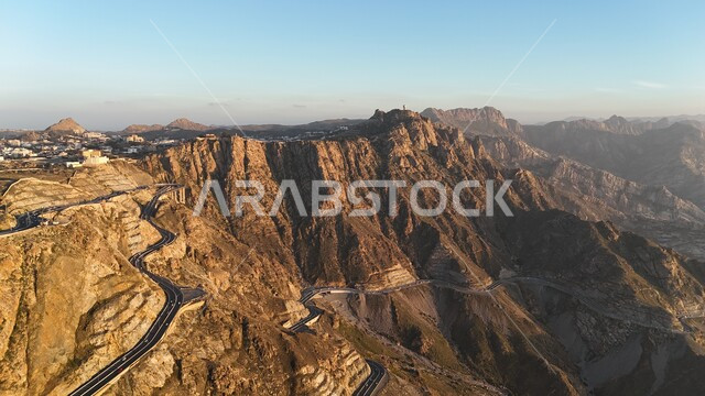 A winding, bumpy asphalt road in the middle of the rocky mountains, the ...