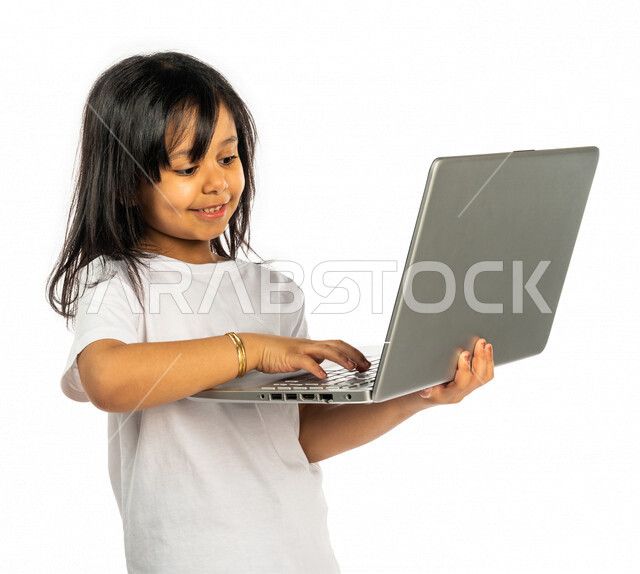 Portrait of a happy Saudi Arabian Gulf girl holding a laptop in her ...