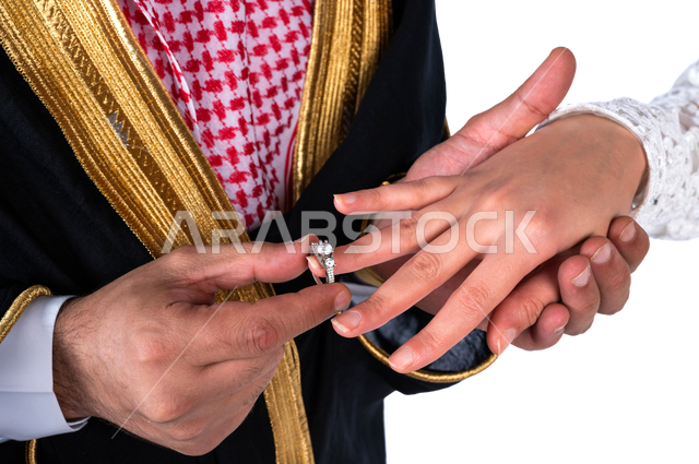 A close-up portrait of a groom in the official Saudi attire, and a ...