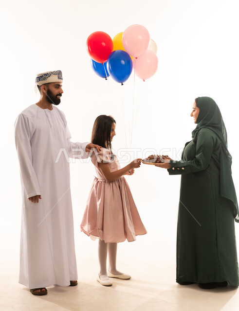 Wearing traditional Omani costumes, distributing traditional sweets ...