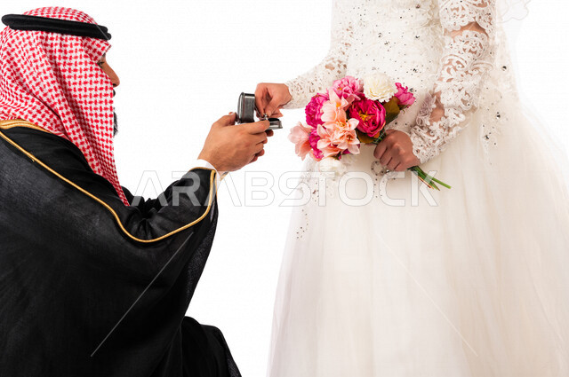 A close-up portrait of a groom in the official Saudi attire, and a ...