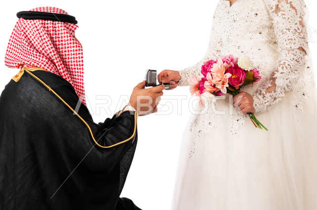 A close-up portrait of a groom in the official Saudi attire, and a ...